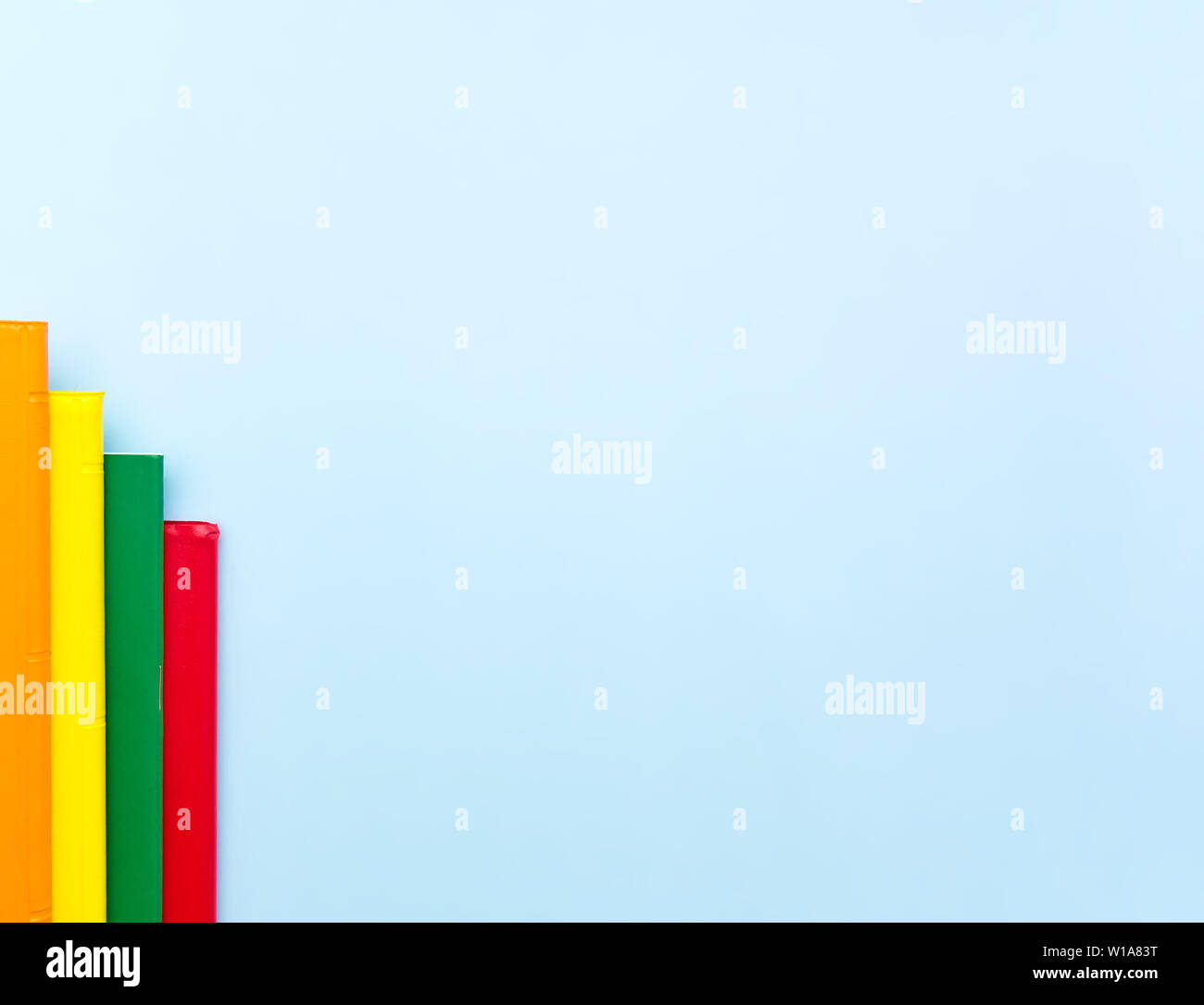 Bar chart made from colorful notebooks on light blue background with ...