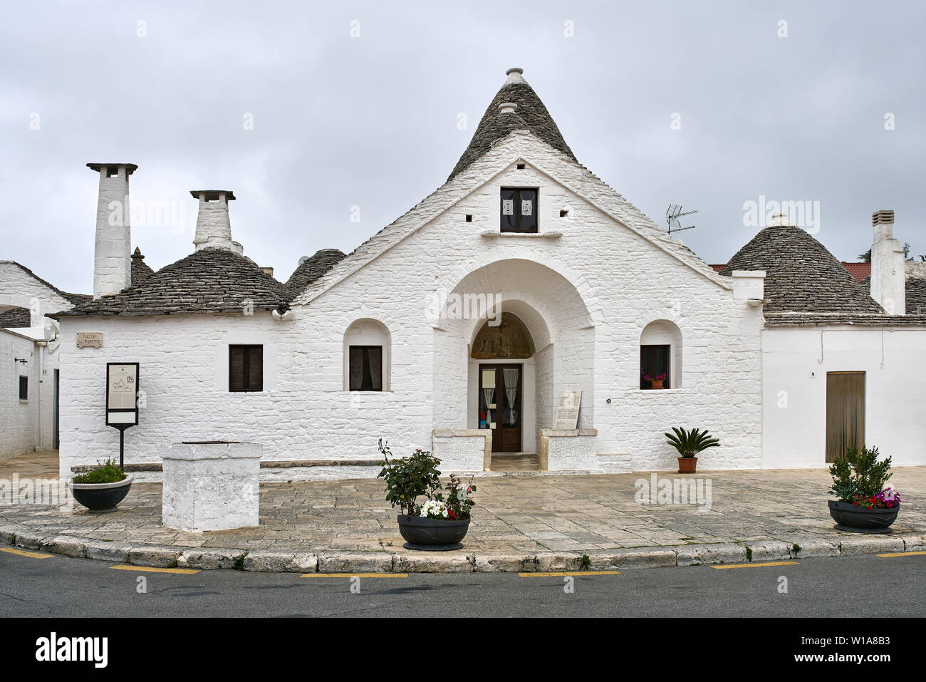 Trullo Sovrano museum with a conical roof on the cloudy sky background ...