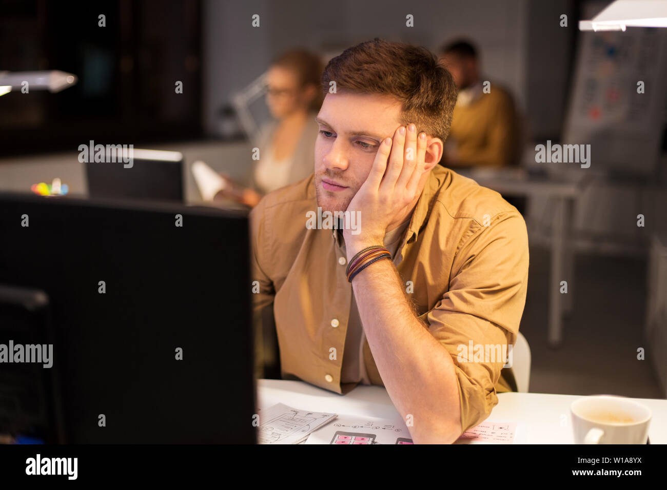 tired or bored man with computer at night office Stock Photo - Alamy