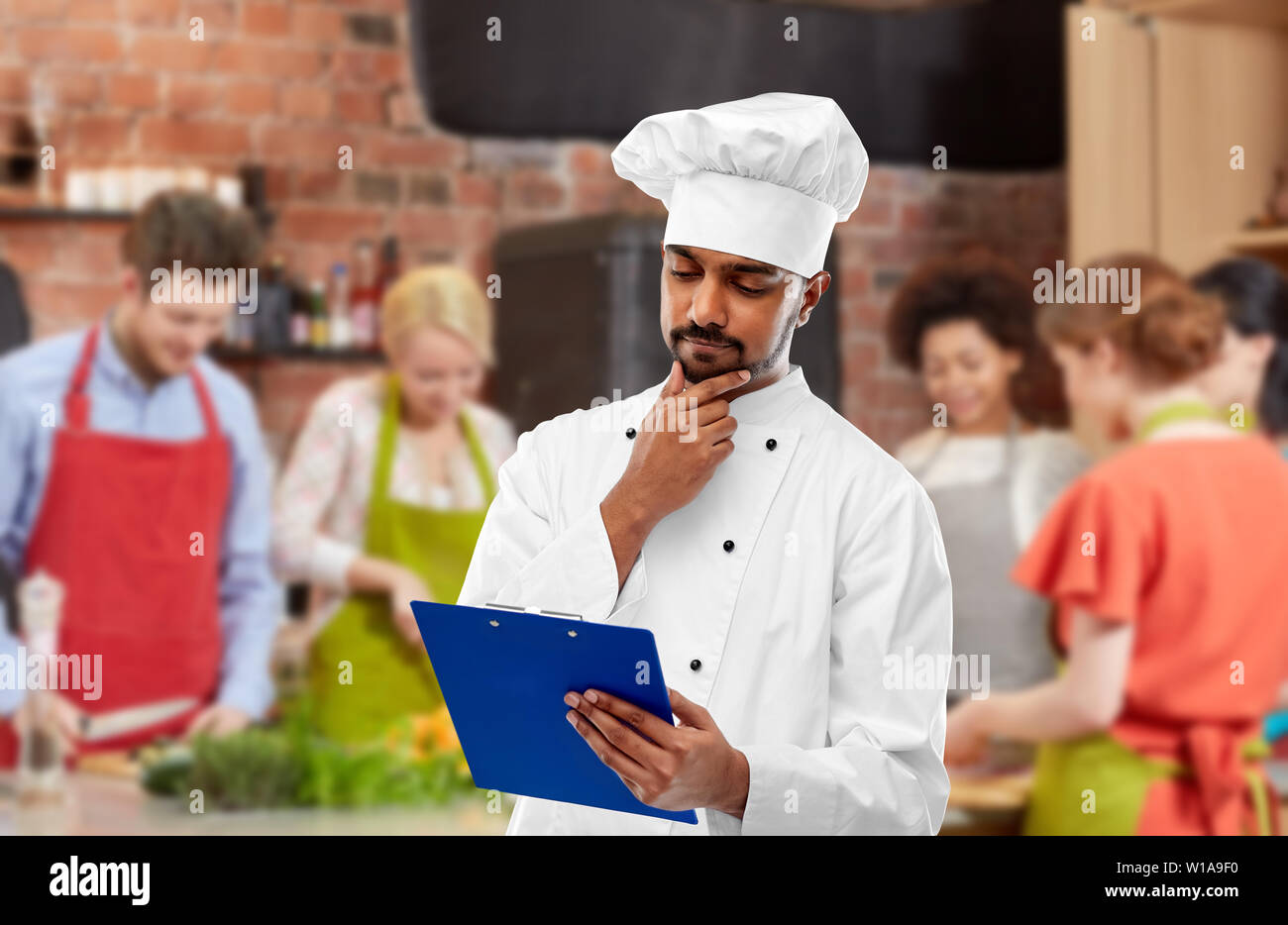 chef with menu on clipboard at cooking class Stock Photo - Alamy