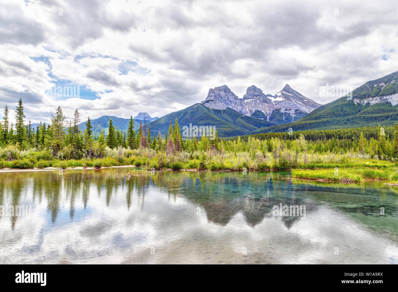 Wide angle view of Canmore's famous Three Sisters mountain peaks and ...