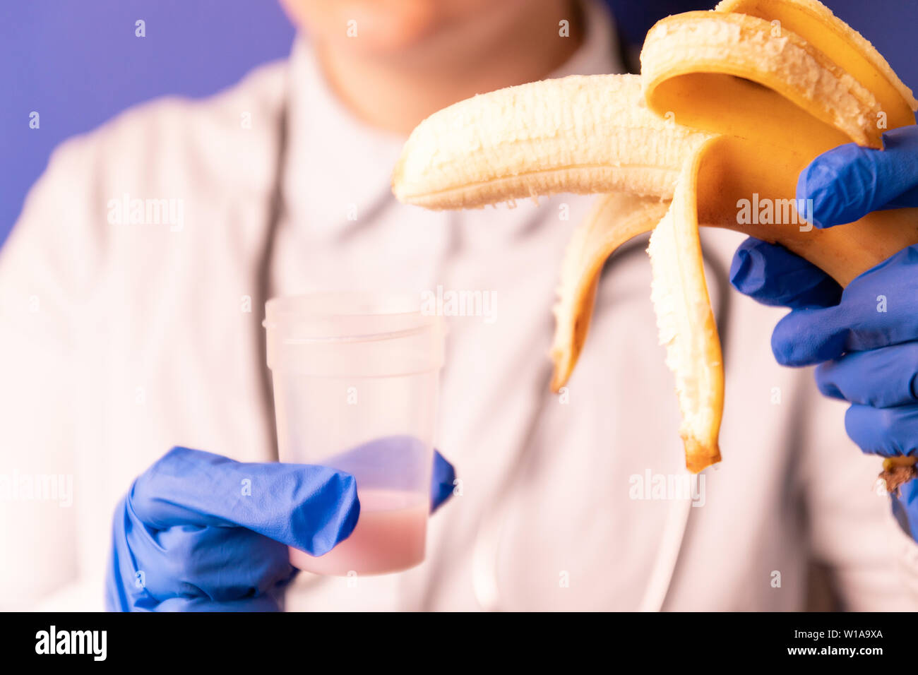 Female doctors hands in medical blue gloves holding a plastic container ...