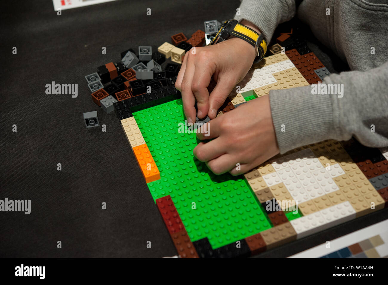 Building a Lego bricks mosaic at the table Stock Photo - Alamy