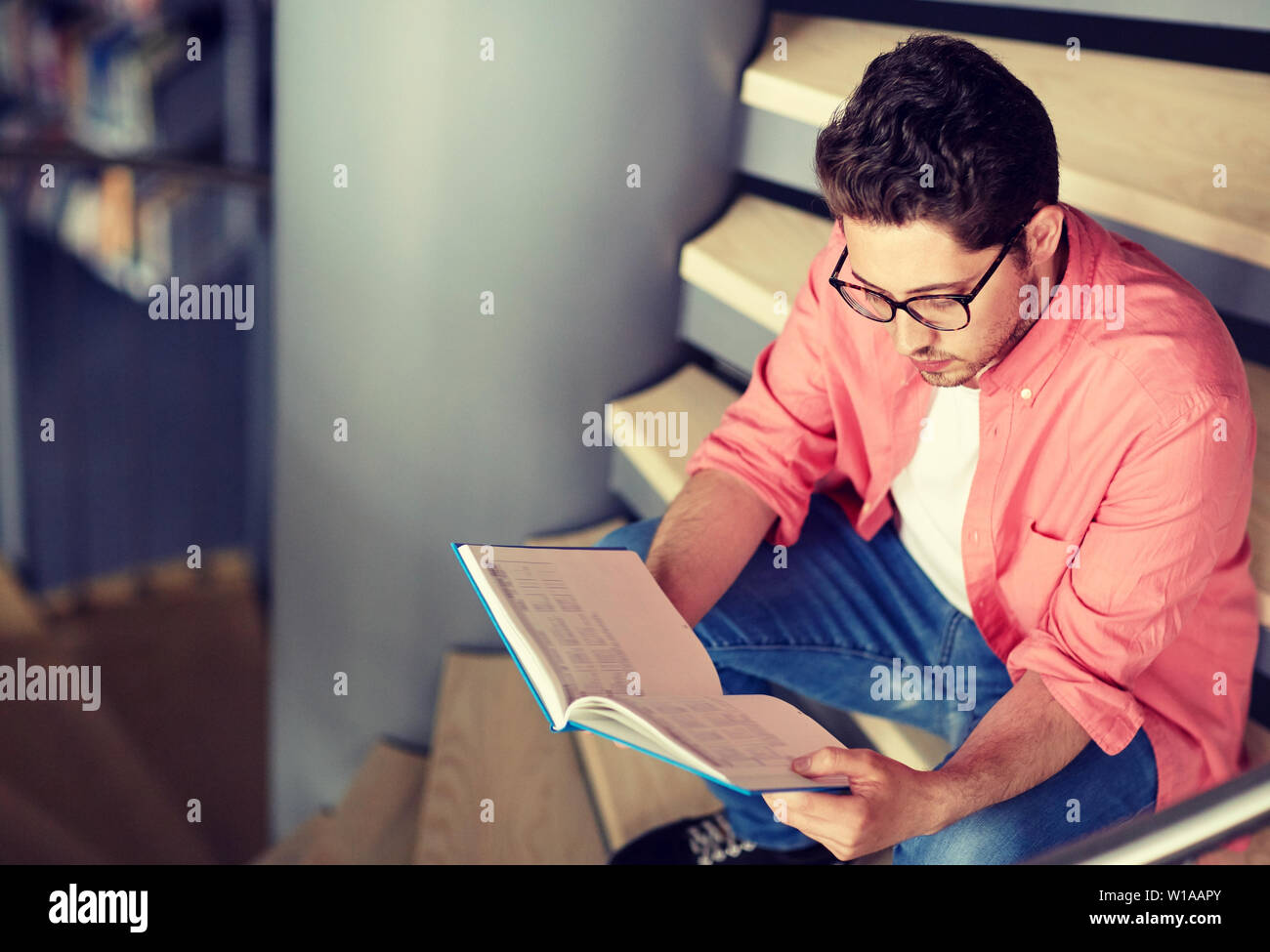 student boy or young man reading book at library Stock Photo - Alamy