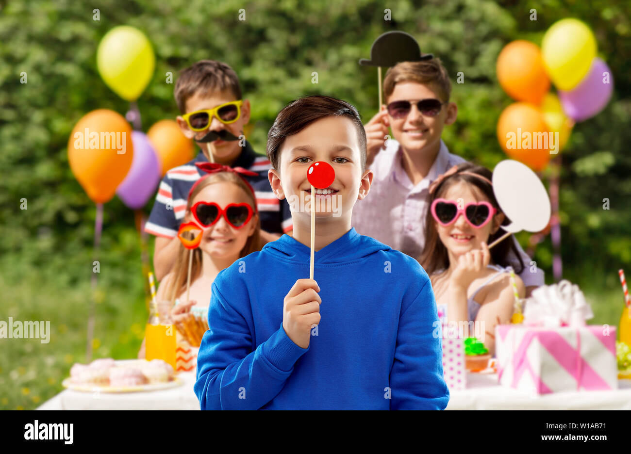 happy boy with red clown nose at birthday party Stock Photo - Alamy