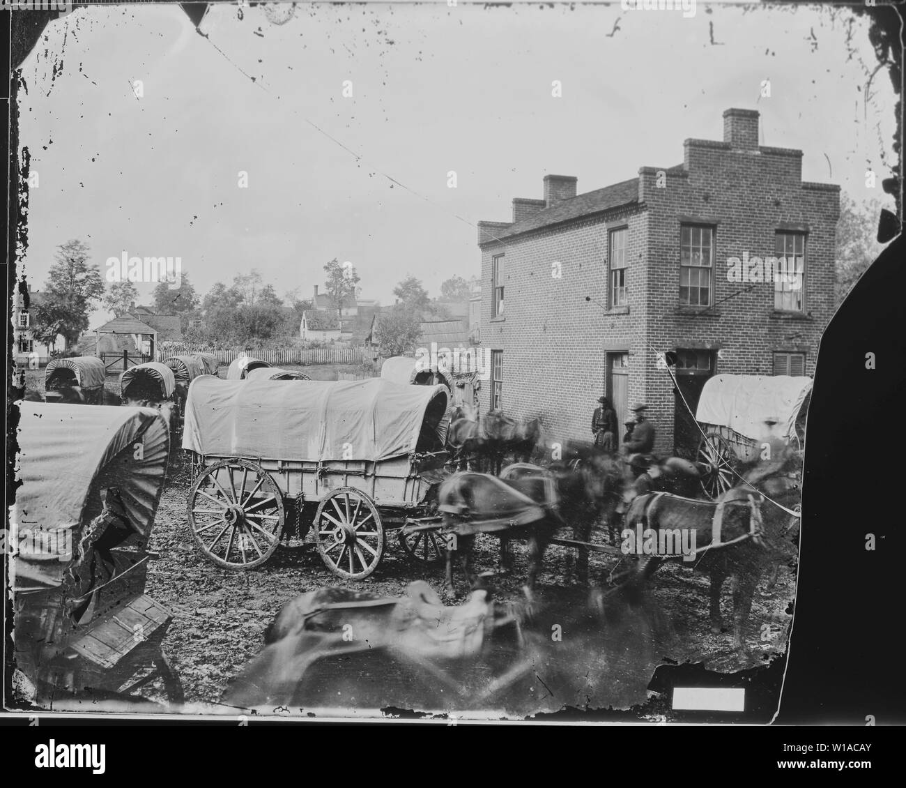 [View of a brick building, and wagons with teams of horses.] Stock ...