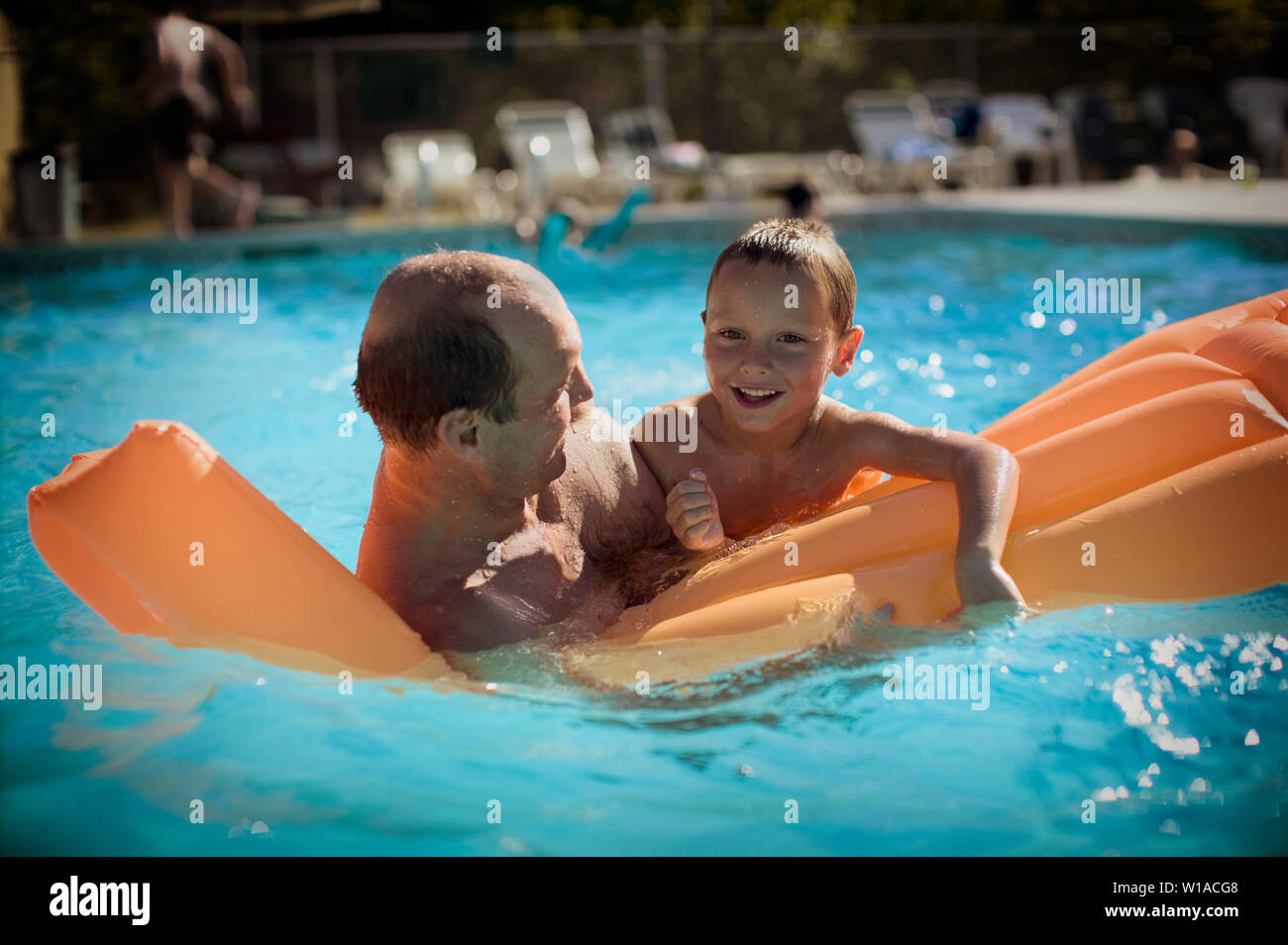 father and son playing in pool on raft Stock Photo - Alamy