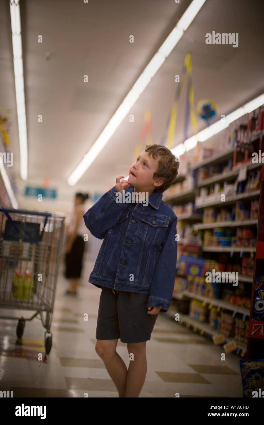 Young boy walking through a supermarket Stock Photo - Alamy