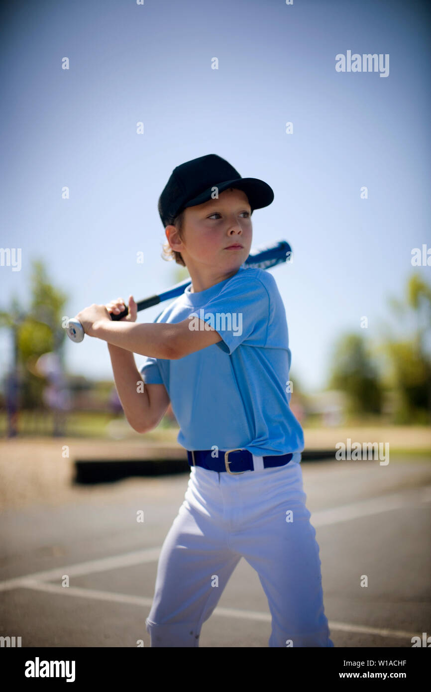 Young boy swinging a baseball bat Stock Photo - Alamy