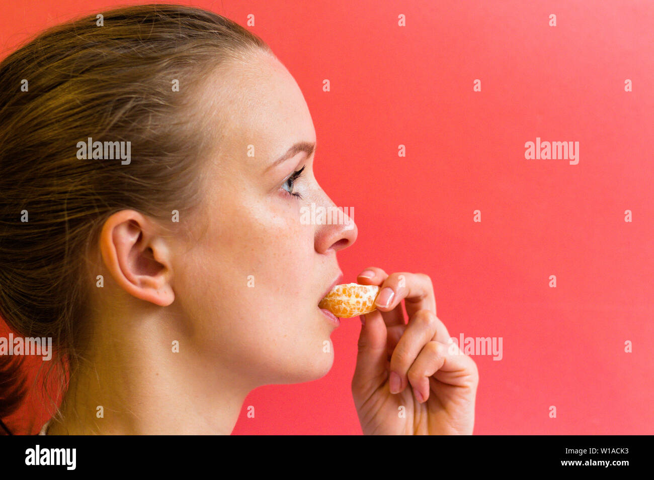 Beautiful And Young Girl Eats Juicy Mandarin She Enjoys A Tasty And