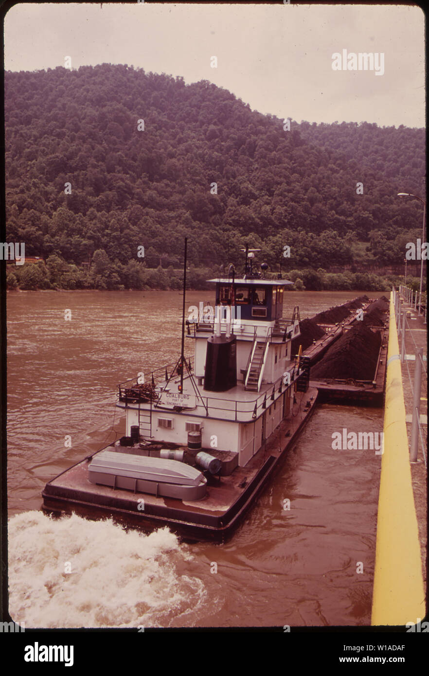 A COALBURG TUG AND EIGHT COAL BARGES GO DOWNSTREAM THROUGH THE LONDON ...
