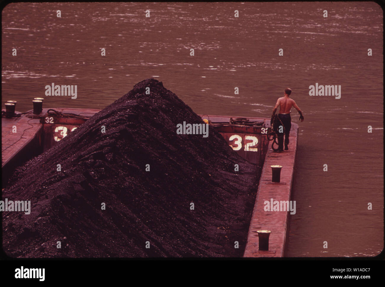 A COALBURG TUG AND EIGHT COAL BARGES GO DOWNSTREAM THROUGH THE LONDON ...