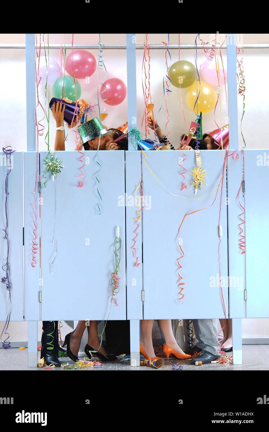 Group of people inside a bathroom stall celebrating a holiday balloons ...