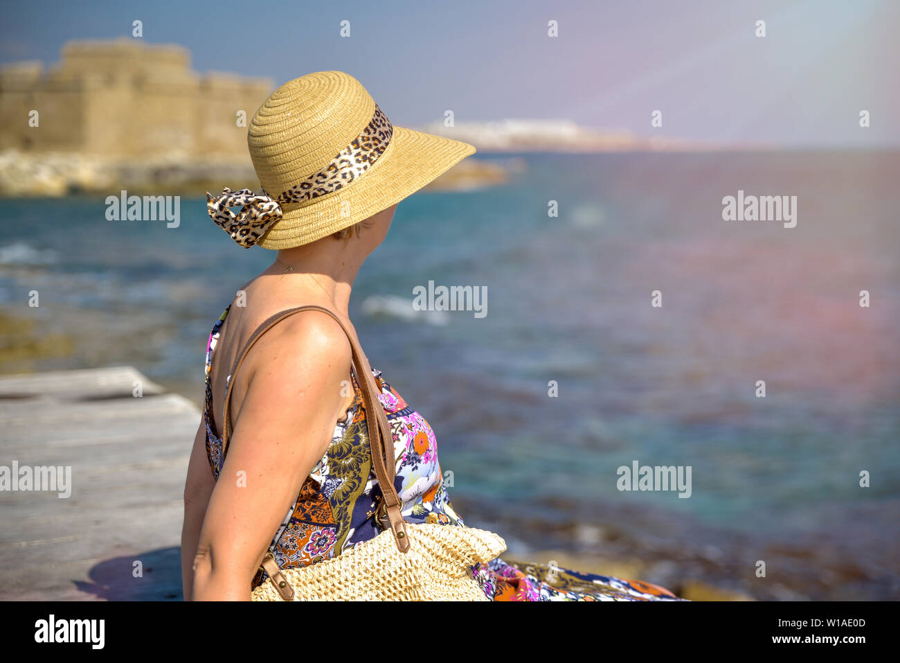 Attractive mature woman sitting on pier. Cyprus, relaxation Stock Photo ...