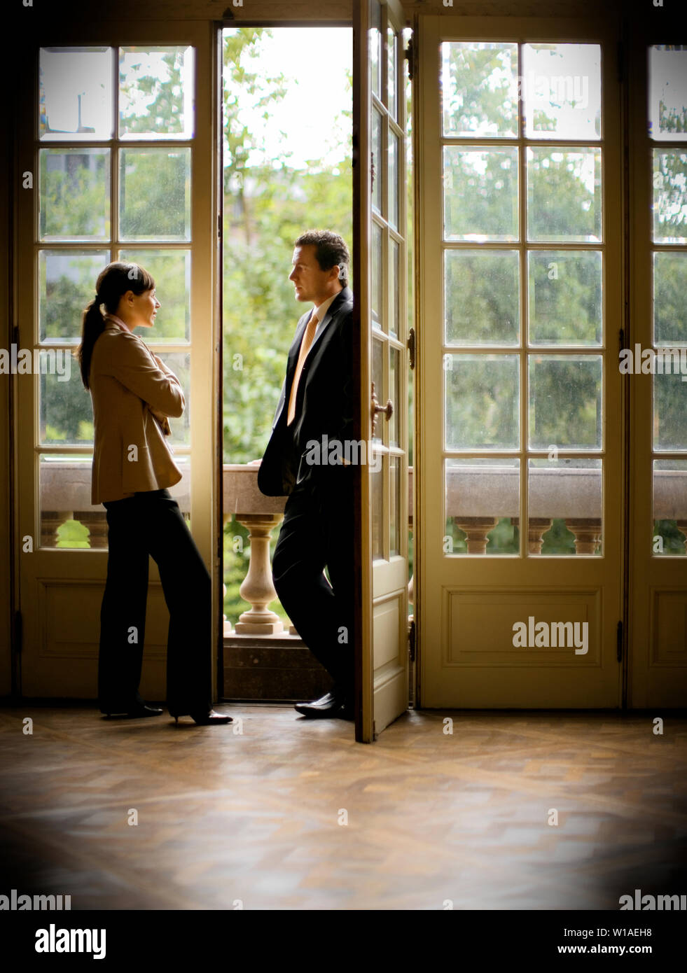 Side view of a couple in an animated conversation Stock Photo - Alamy