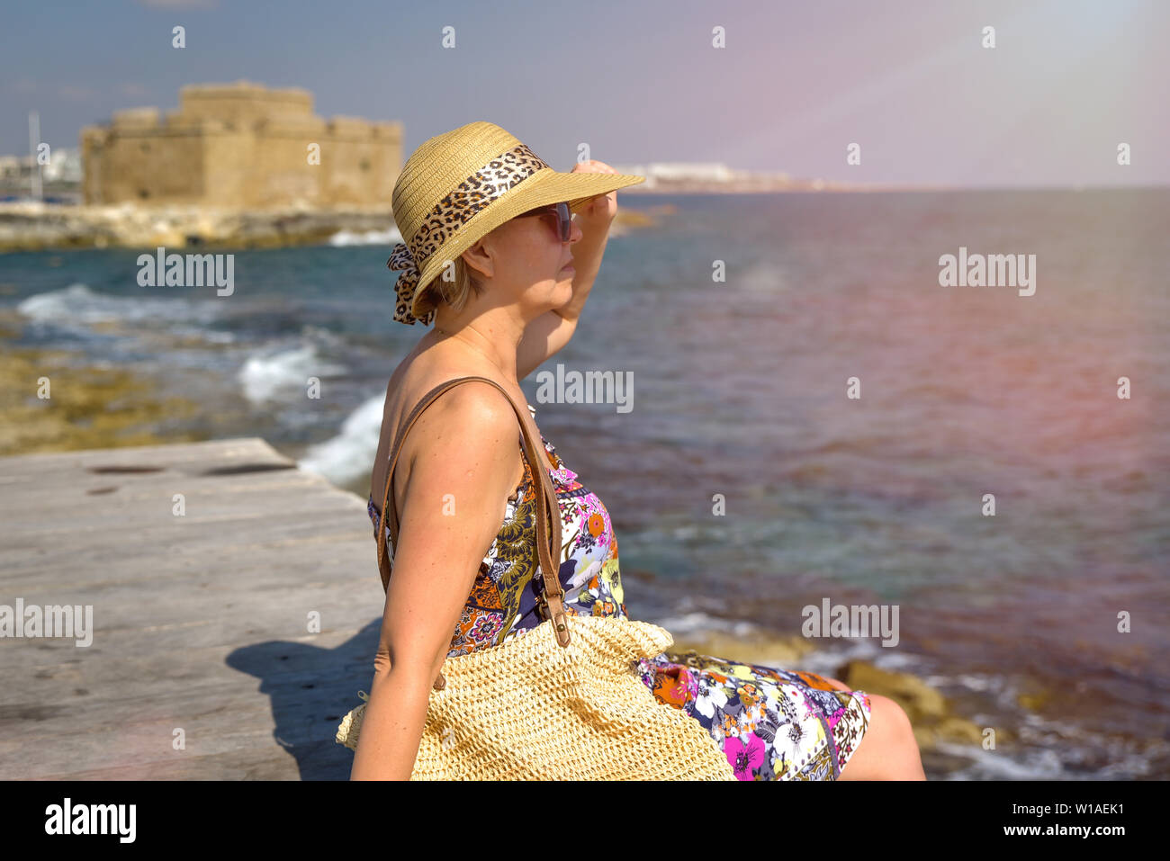 Attractive mature woman sitting on pier. Cyprus, relaxation Stock Photo ...