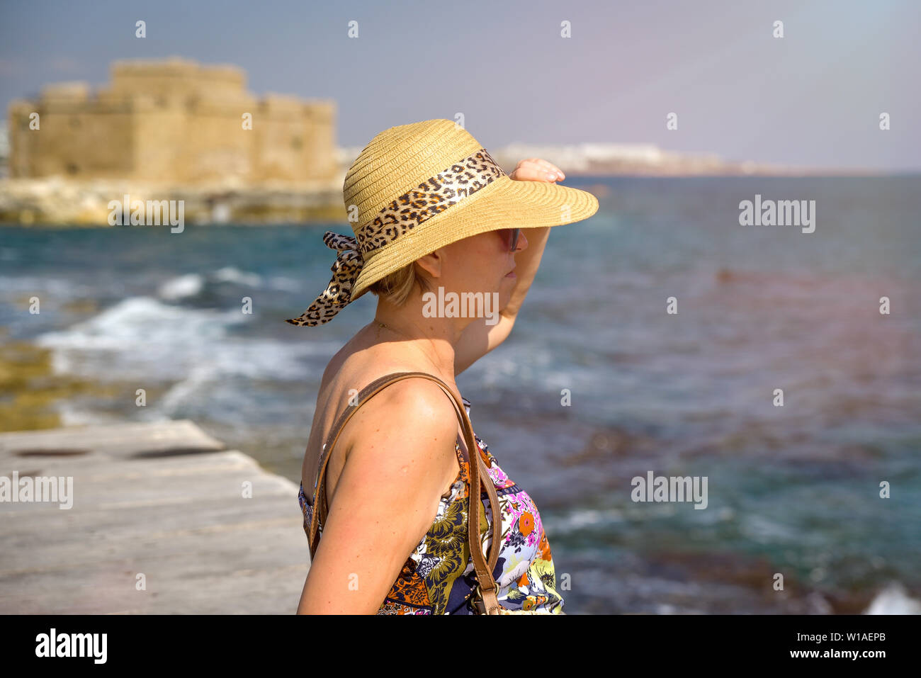 Attractive mature woman sitting on pier. Cyprus, relaxation Stock Photo ...