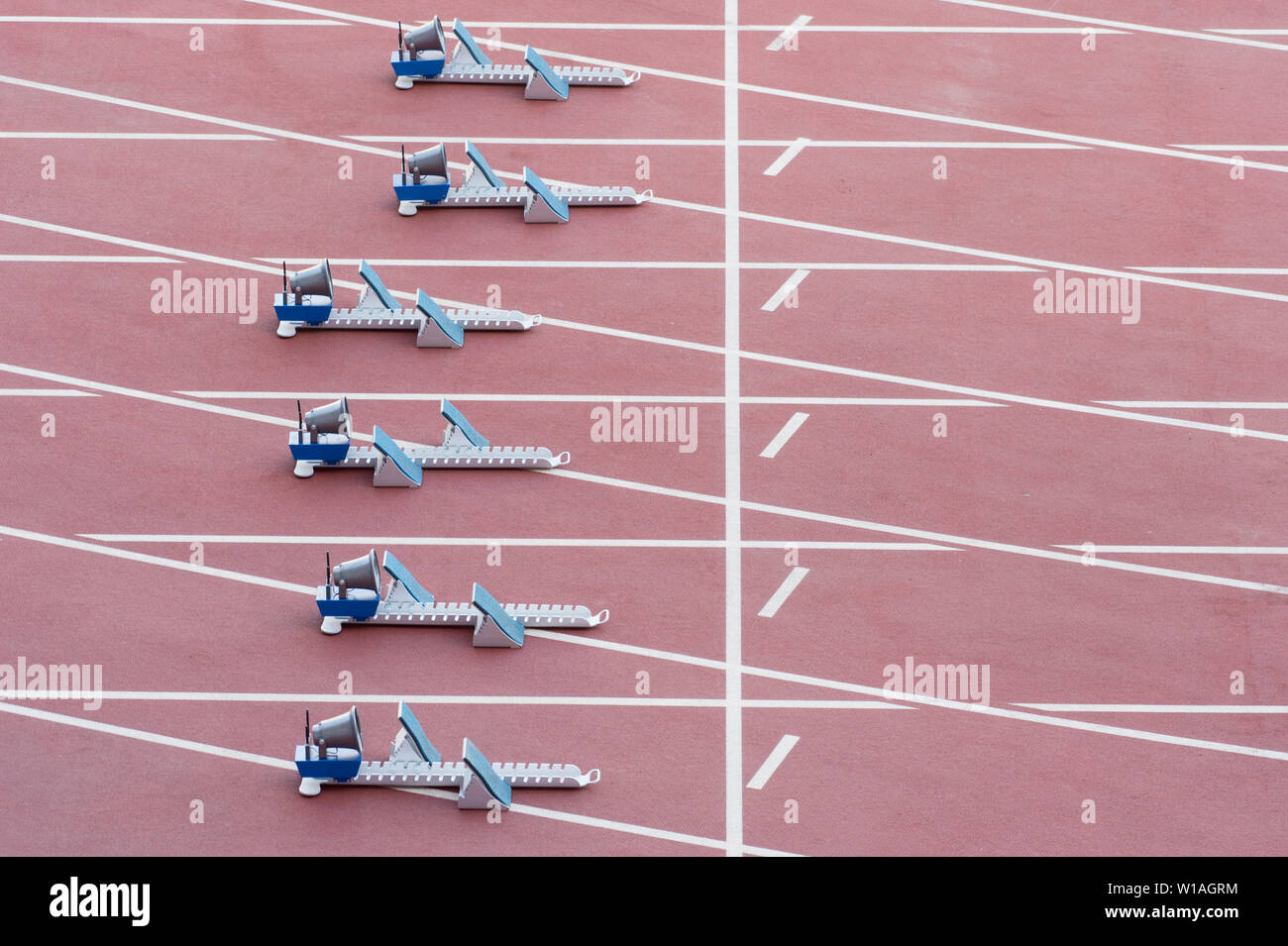 Athletic start block on dark red tartan track Stock Photo - Alamy