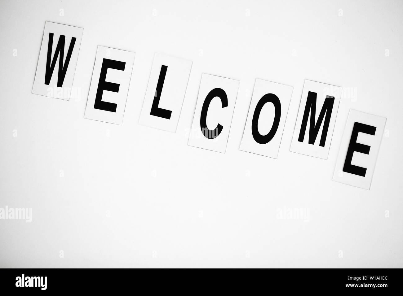 Welcome word written on white table. Copy space Stock Photo - Alamy