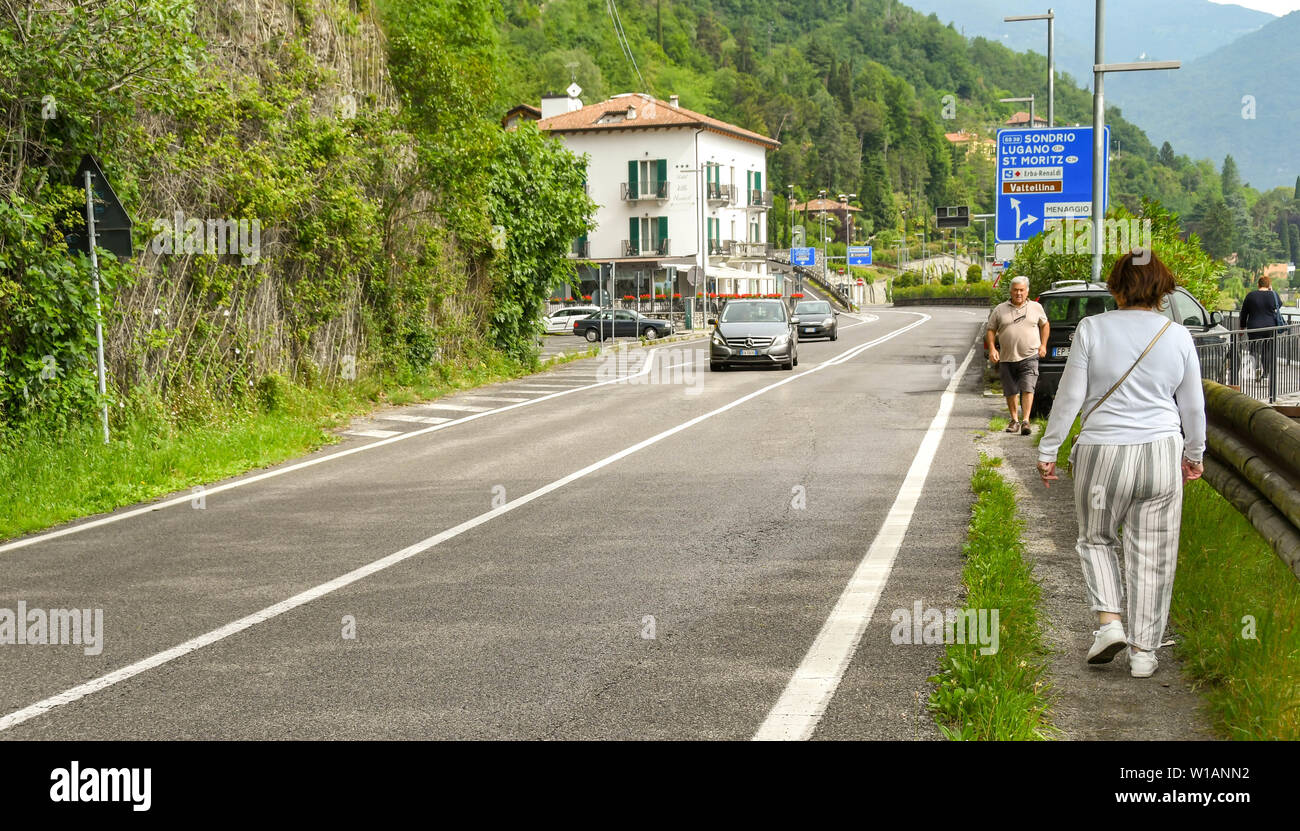 LAKE COMO, ITALY - JUNE 2019: Person walking alongside traffic on the ...