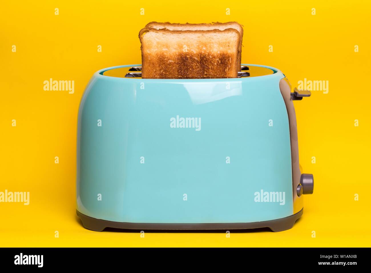 bright, fun breakfast. cyan color toaster on a yellow background Stock ...