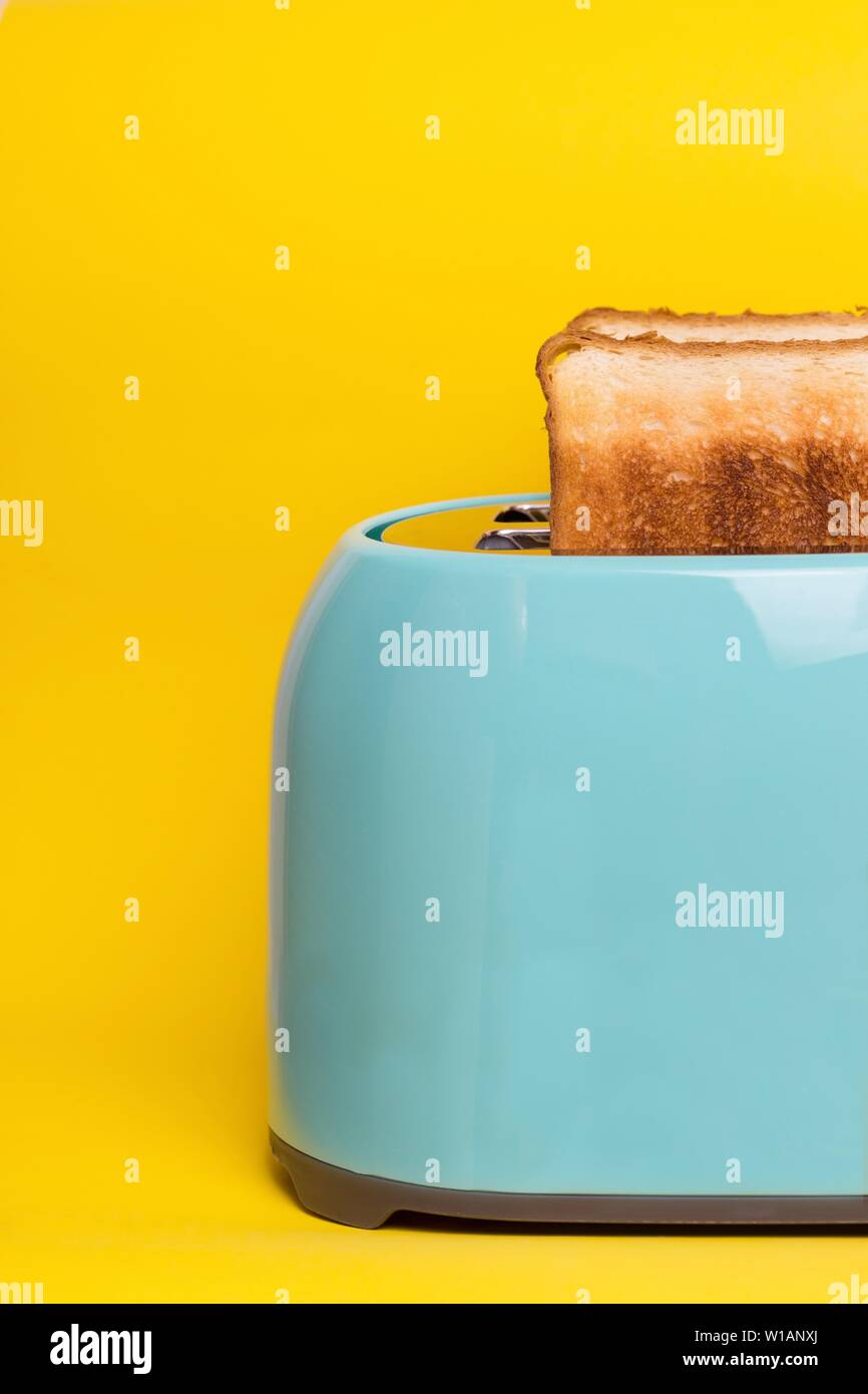 bright, fun breakfast. cyan color toaster on a yellow background Stock ...