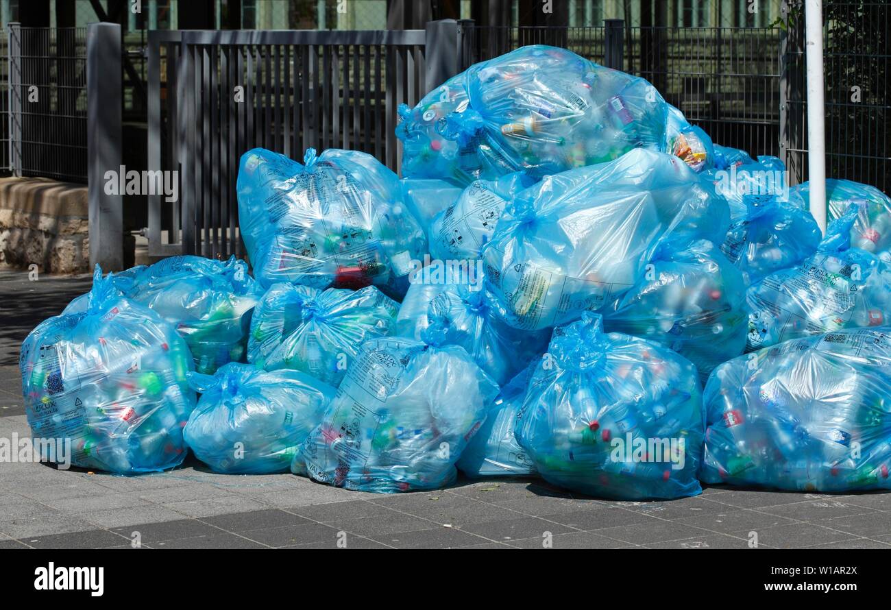 Full light blue garbage bags with plastic garbage on one heap ...