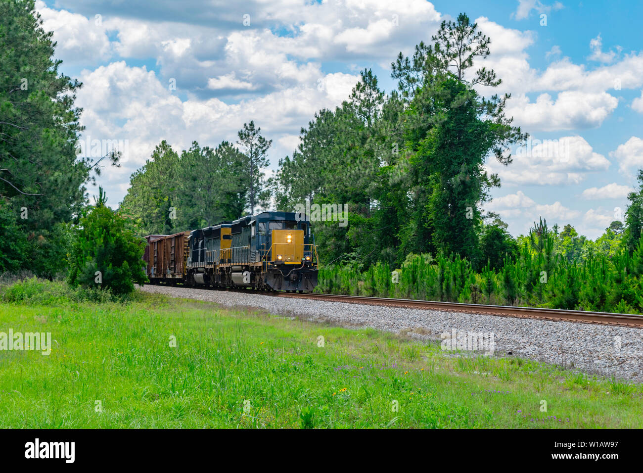 Train on tracks pulling cars Stock Photo - Alamy