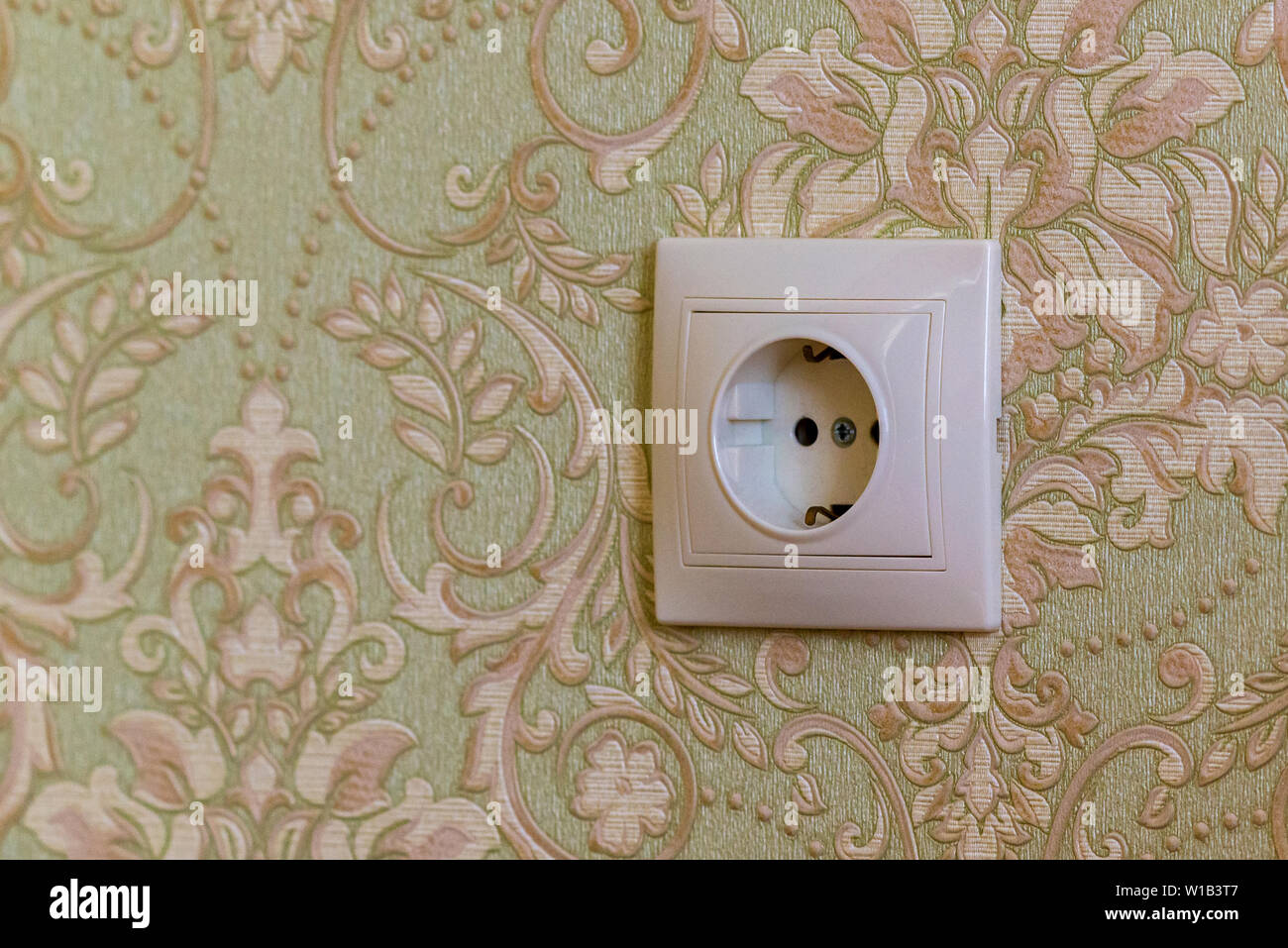 Electric socket on a wall with wallpaper Stock Photo - Alamy