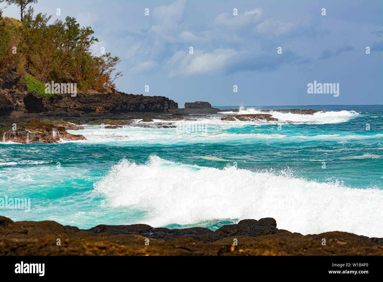 View of waves crashing into the lava rocks to the west of Secret Beach ...