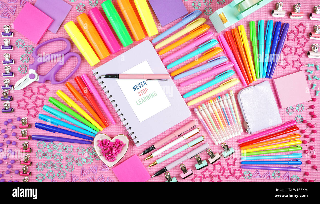 Back to school or workspace colorful stationery overhead on pink ...