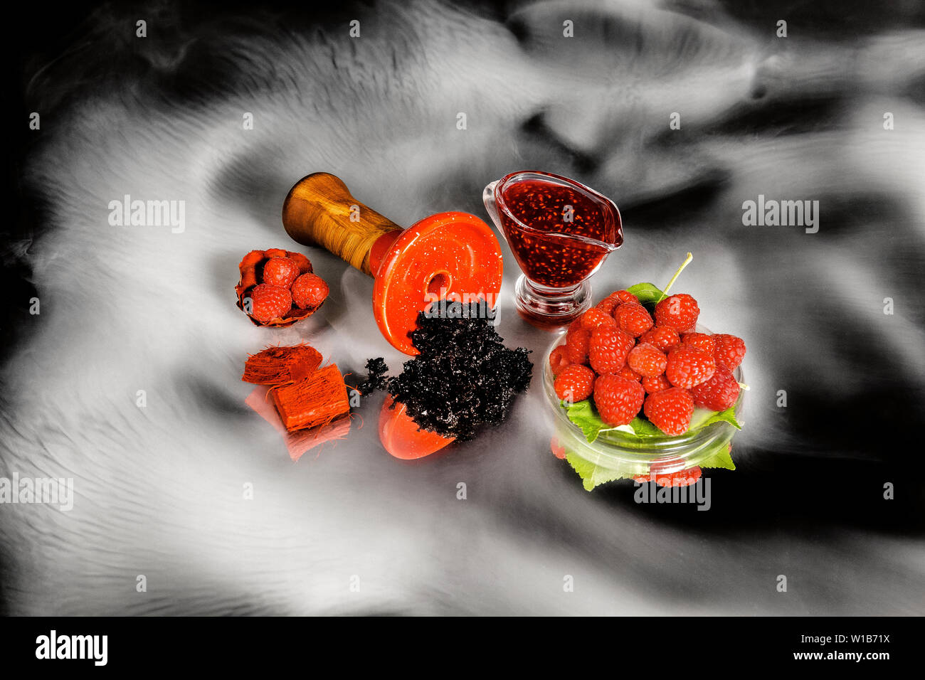 Hookah bowl with tobacco in the smoke. Raspberry jam and berries next ...