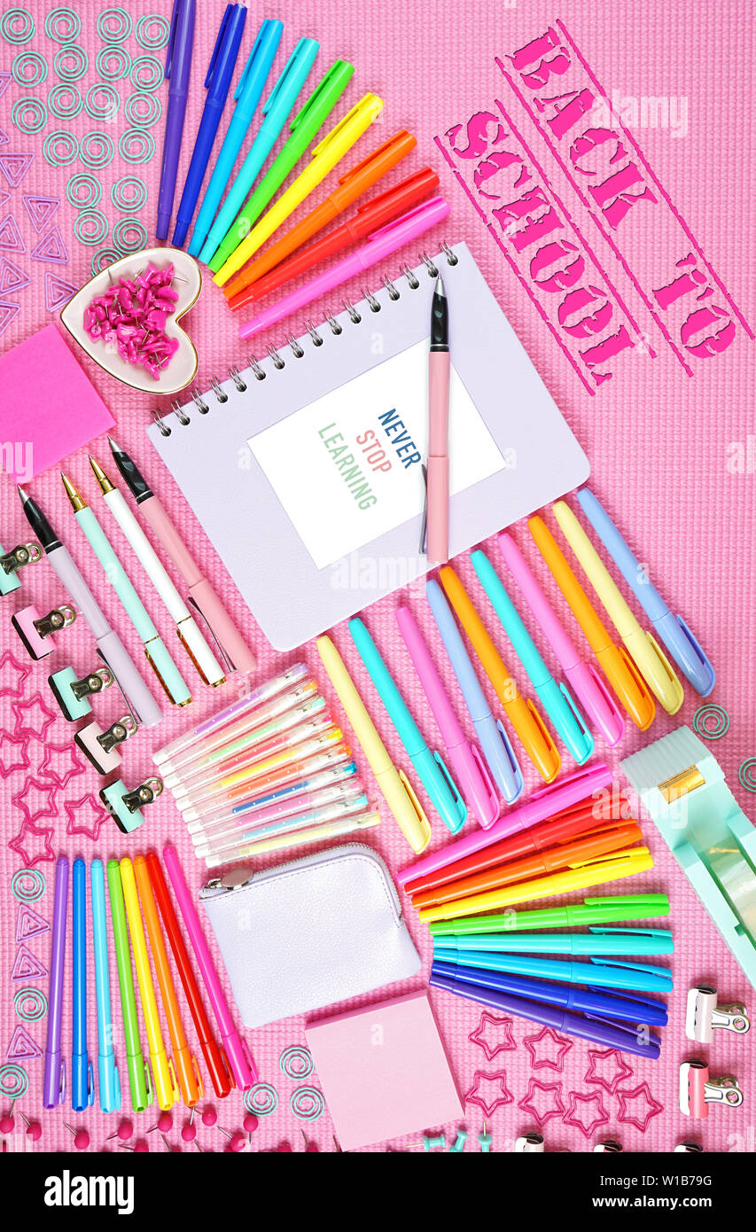 Back to school or workspace colorful stationery overhead on pink ...