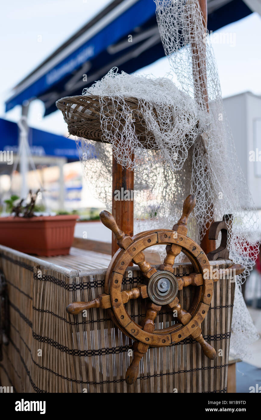 hanging wooden steering wheel and a white fisher net Stock Photo - Alamy