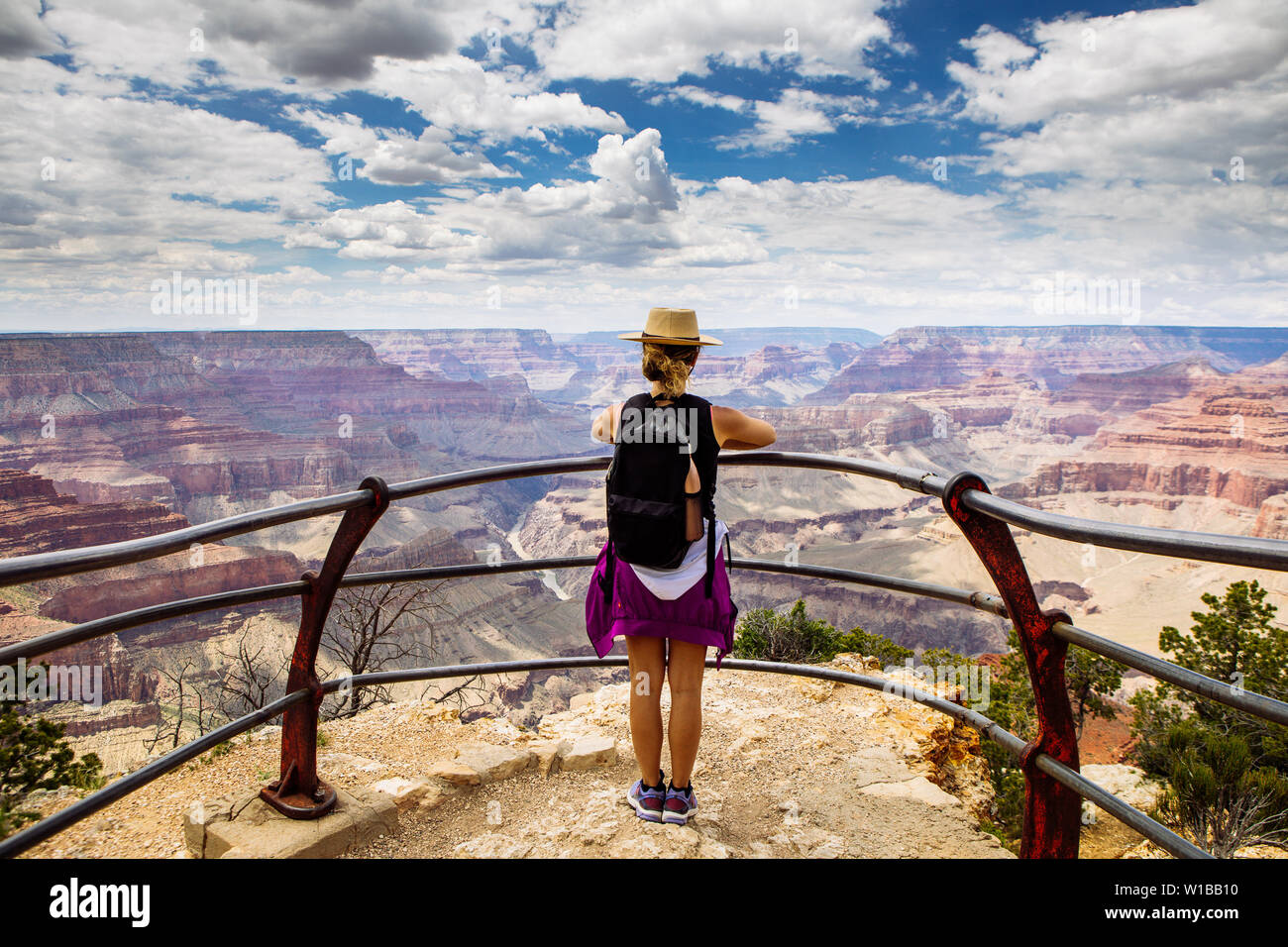 Tourist woman watching and enjoying the views from a railing near a ...