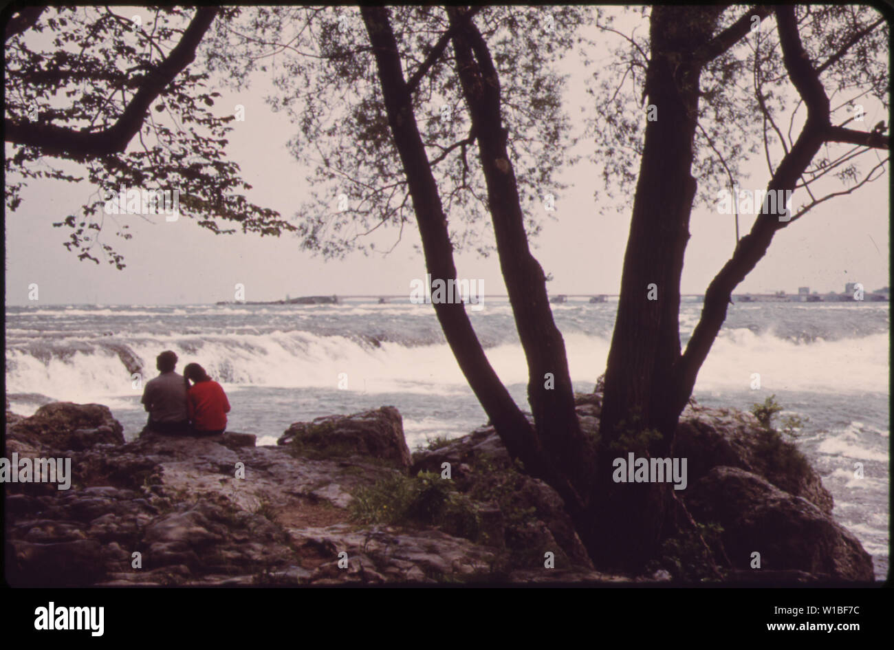 COUPLE ENJOY VIEW OF NIAGARA RIVER RAPIDS FROM THE SHORE OF GOAT ISLAND ...