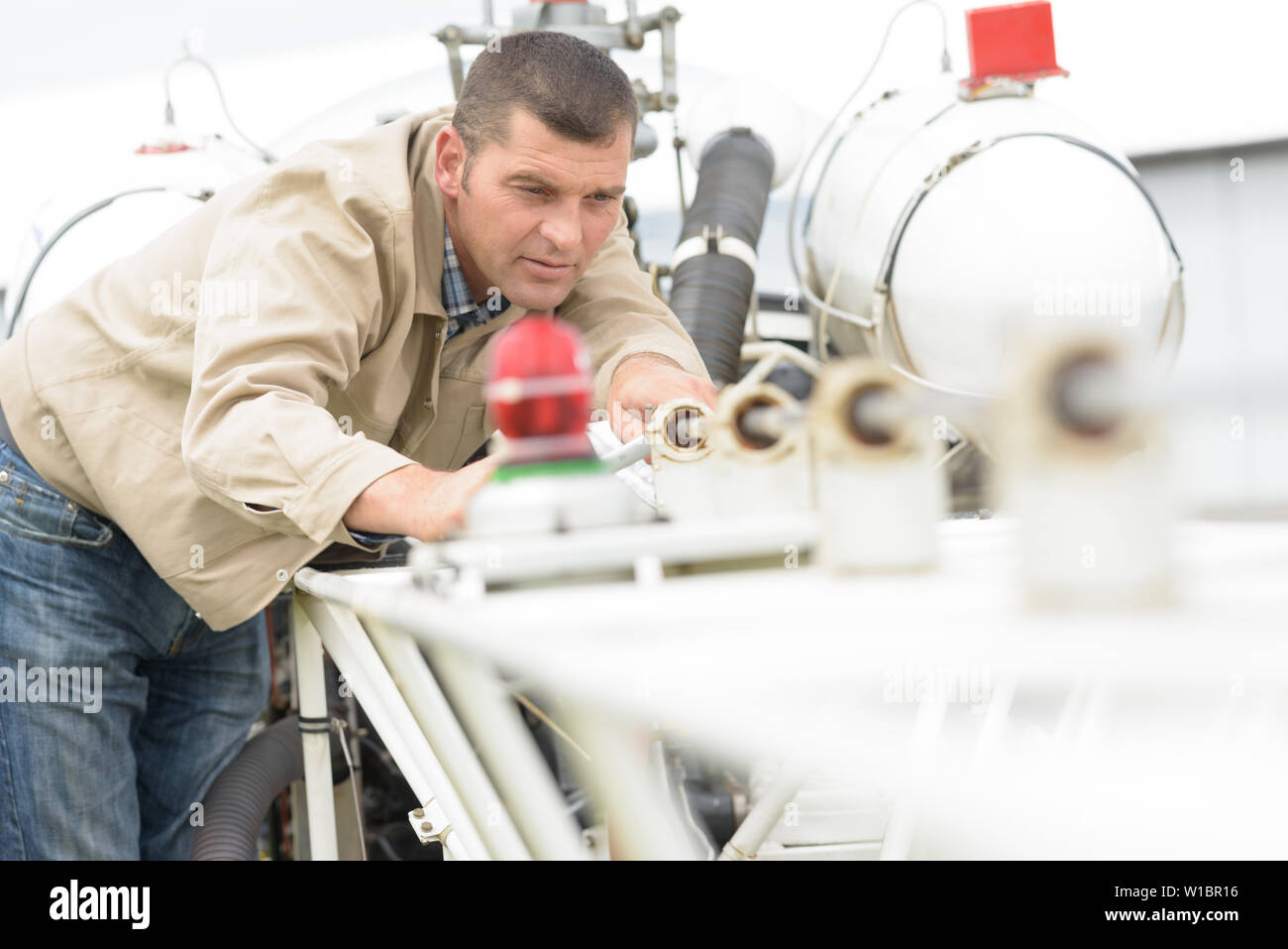 a mechanic is fixing something Stock Photo - Alamy