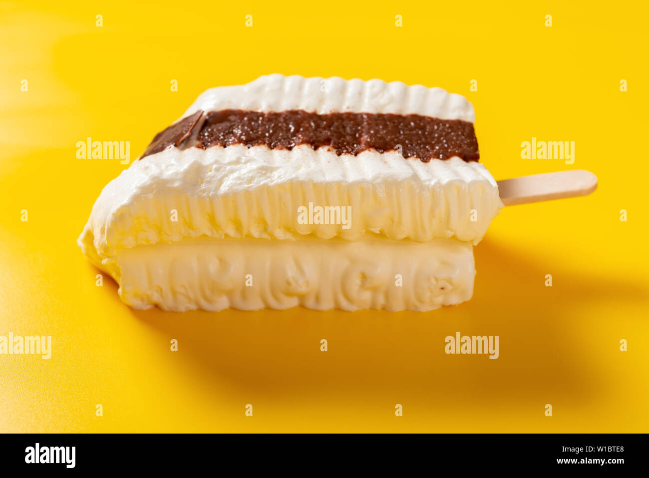 side view fresh chocolate and milkshake flavor popsicle with some bites ...