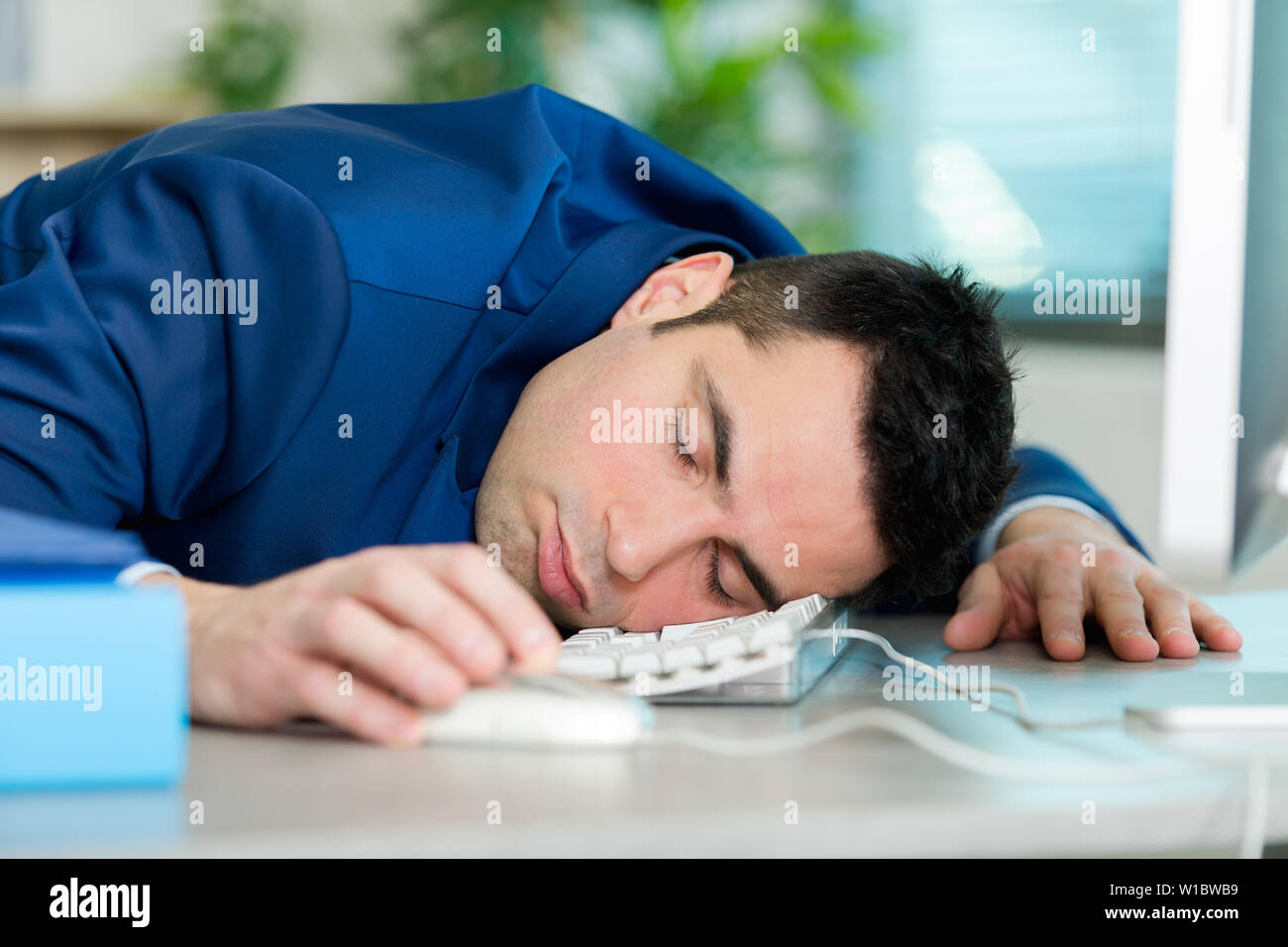 tired overworked man sleeping on keyboard in office at work Stock Photo ...