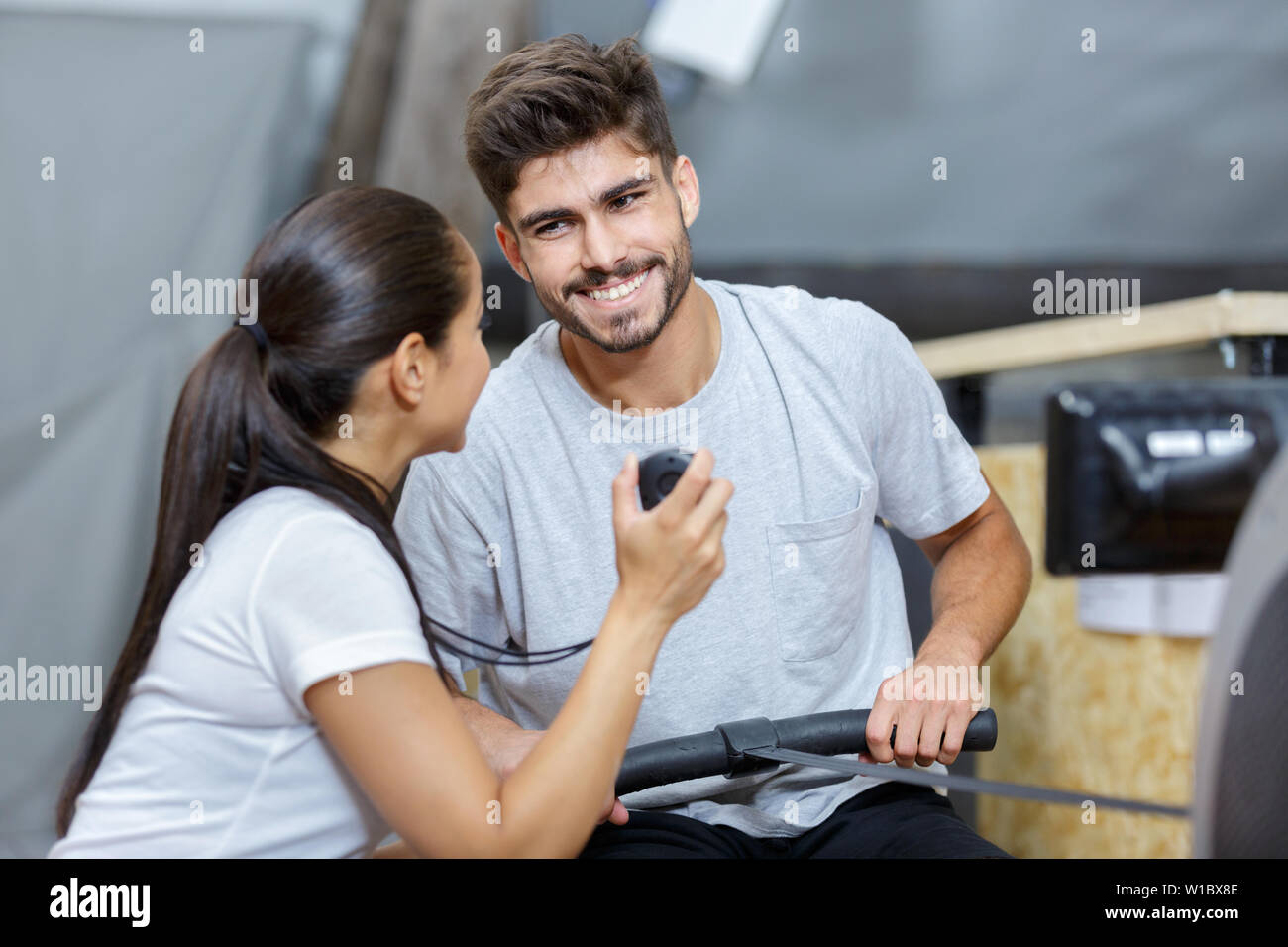 couple training with exercise rowing machines in the gym Stock Photo ...