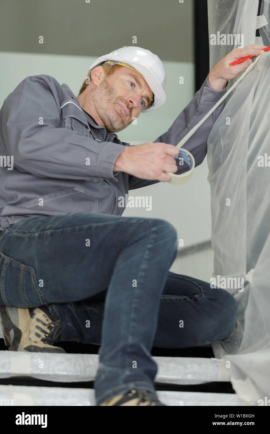 worker protecting objects with masking tape Stock Photo - Alamy