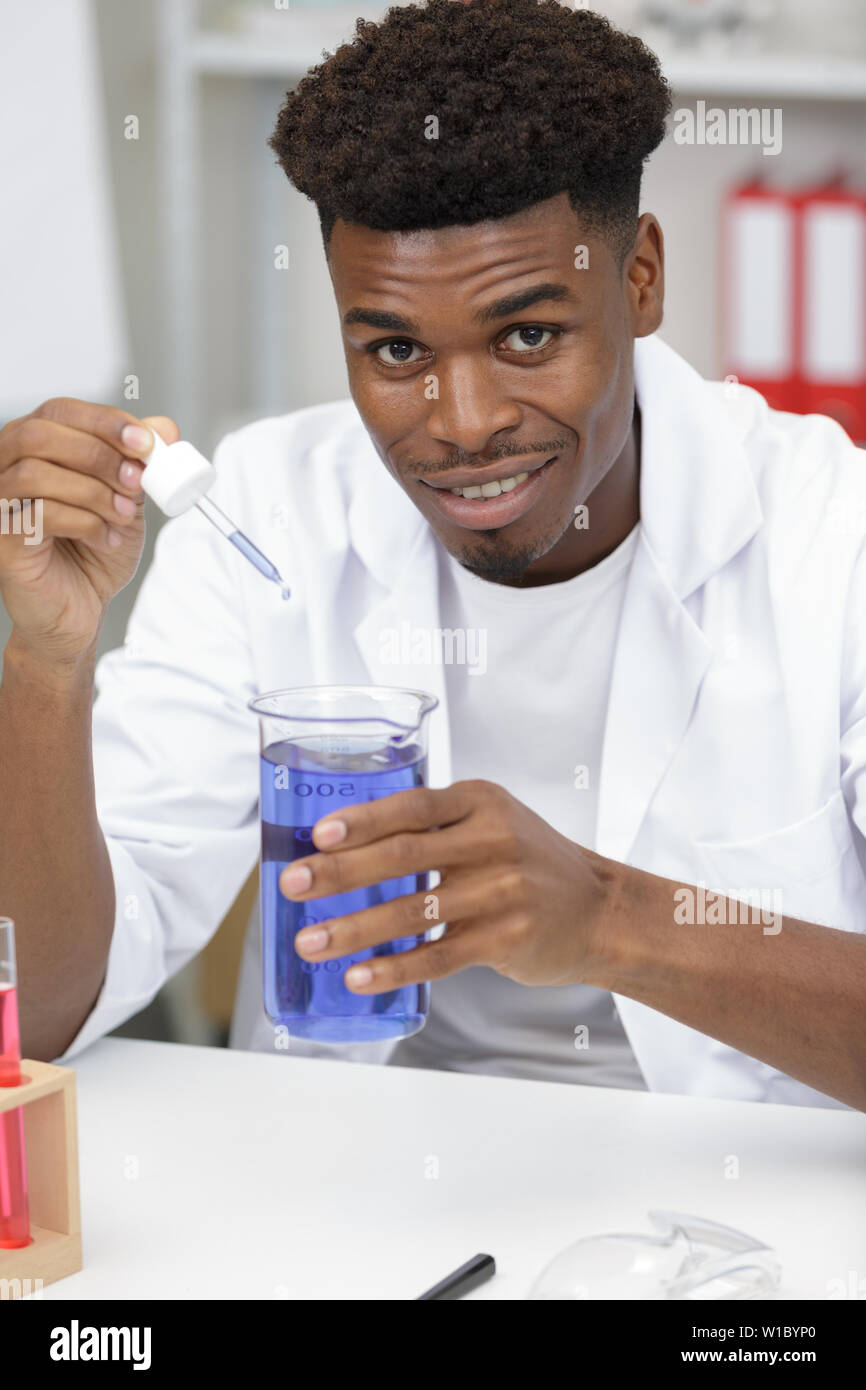scientist dripping blue liquid into test tube Stock Photo - Alamy