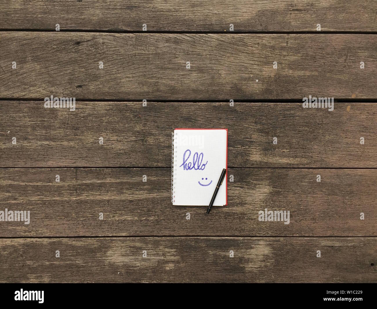 Hello text on notebook. Blank open notepad and black pen on old wood ...