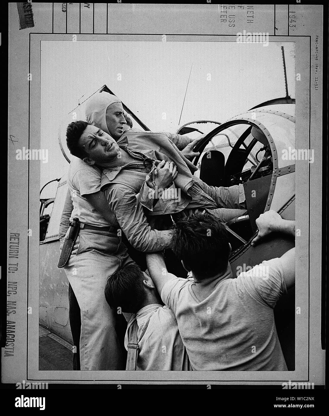 Crewmen lifting Kenneth Bratton (AOM) out of turret of TBF on the USS ...