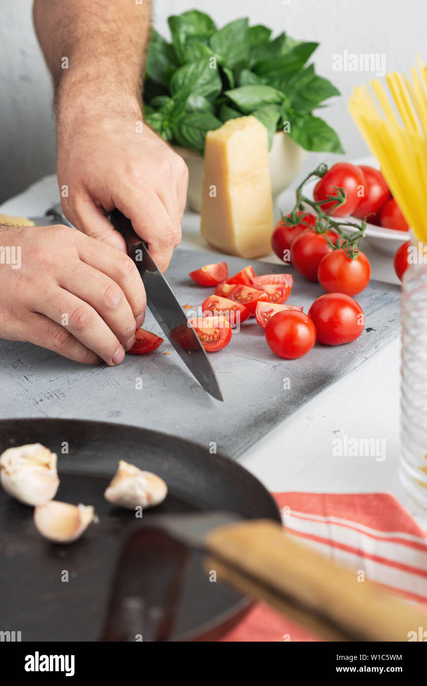 Chef cooking pasta with tomatoes in the kitchen Stock Photo - Alamy