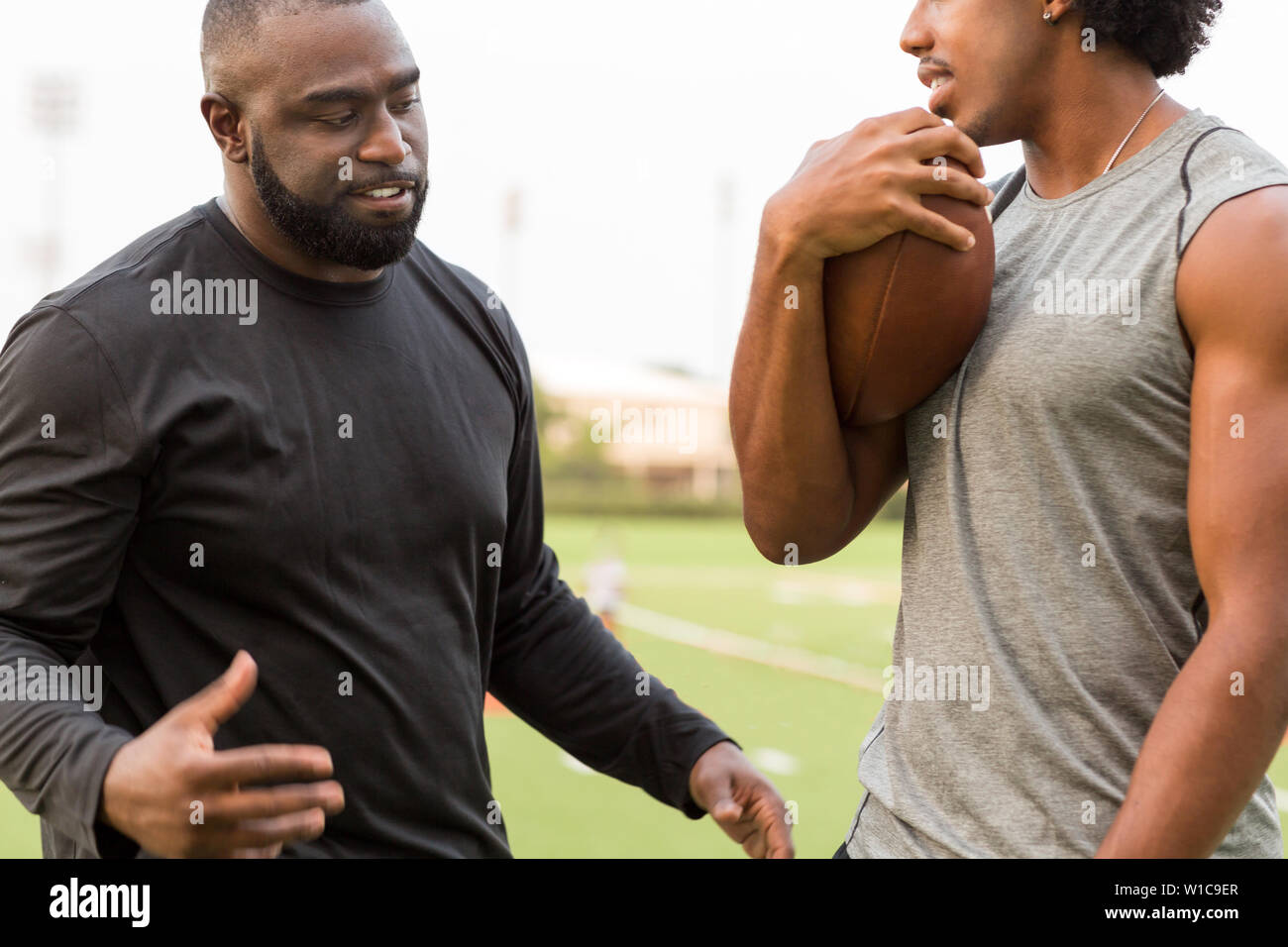 American Football coach training a young athlete Stock Photo - Alamy