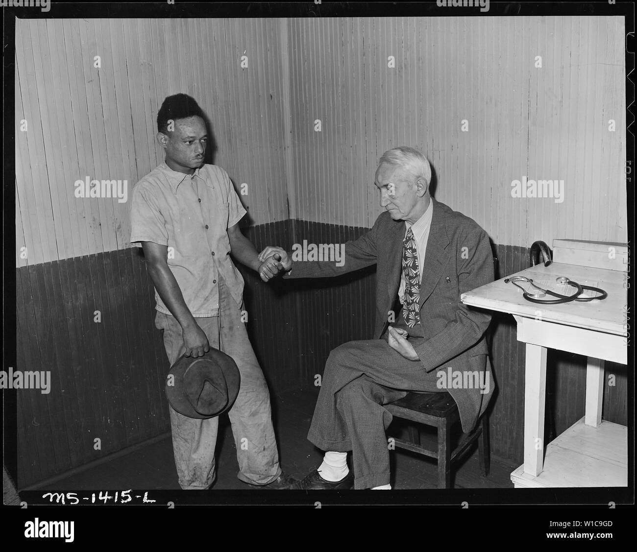 Dr. Rucker takes pulse of miner who has come in for a back-to-work slip ...