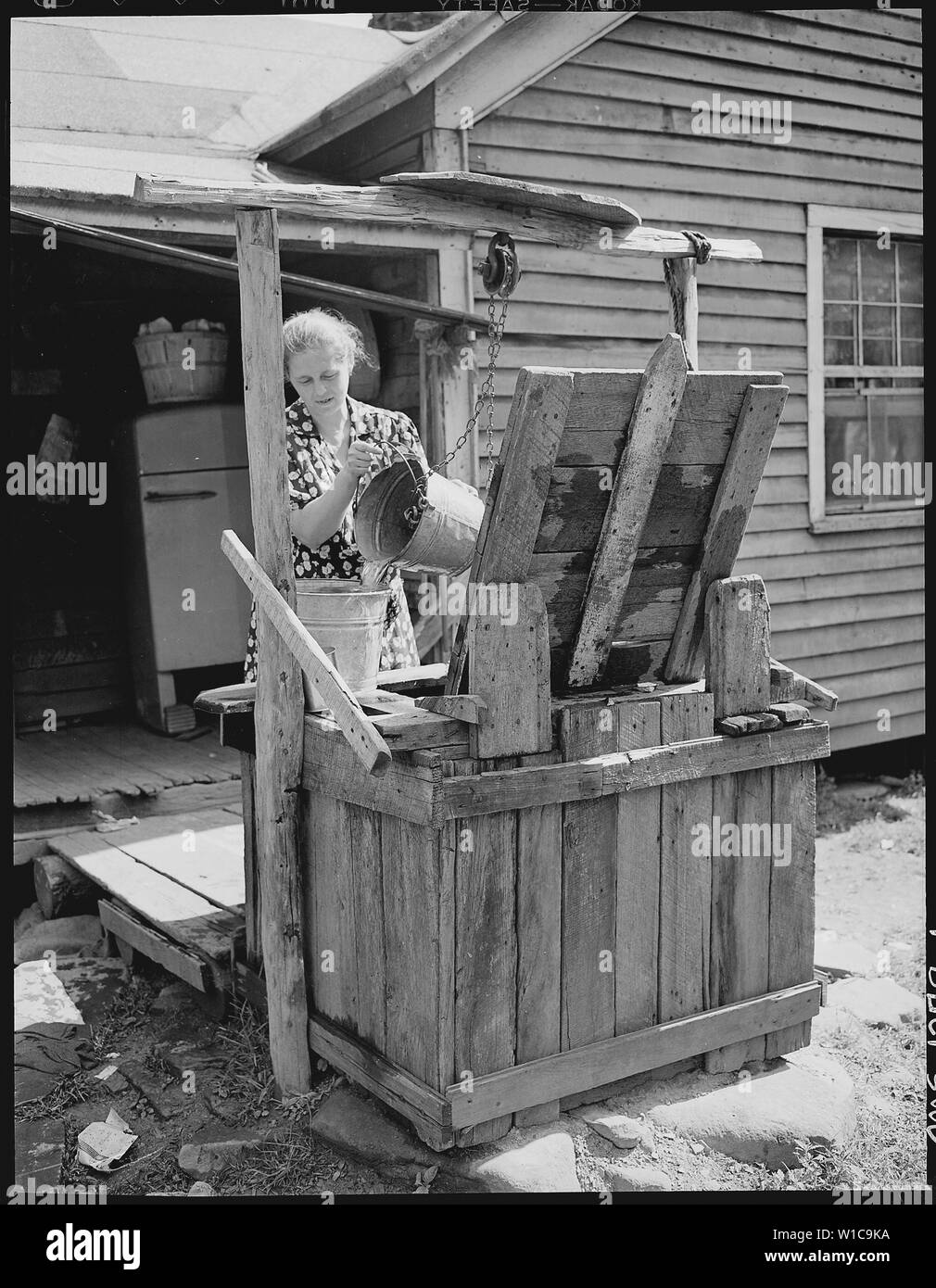 Drawing water from well at farm house where annual reunion of England ...