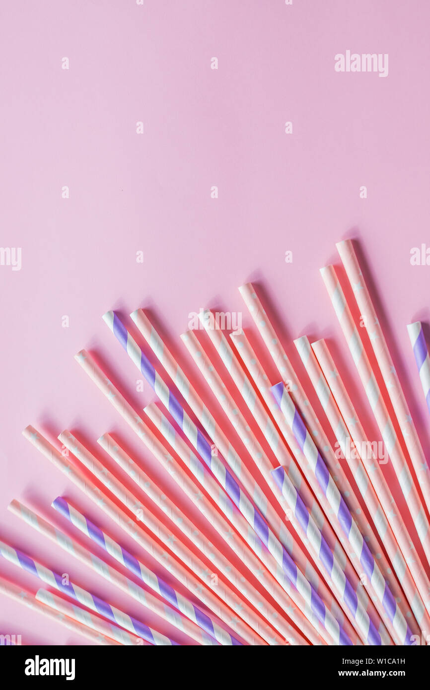 row of drinking straws with stripe and polka dot design border on pink ...