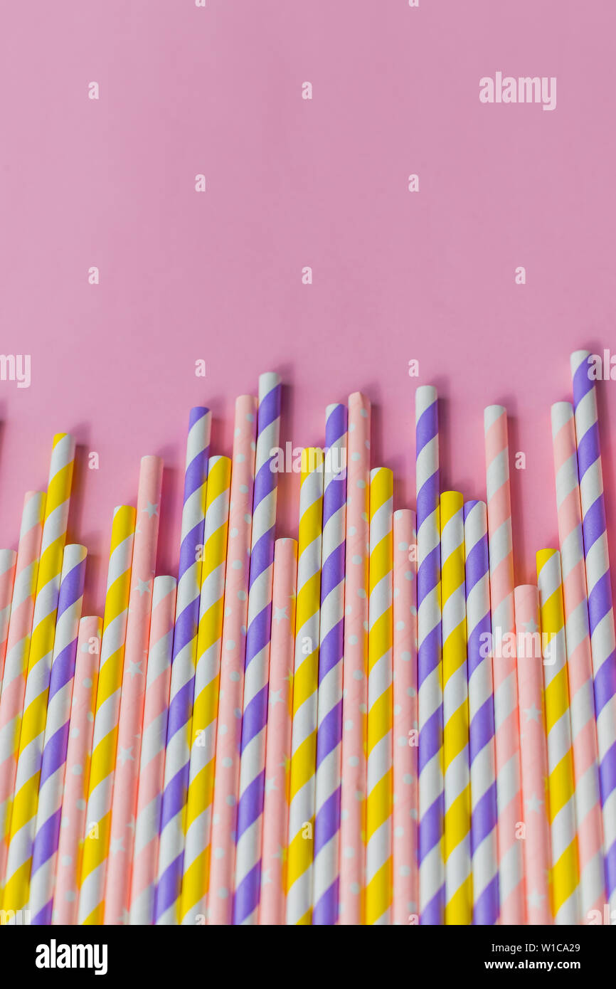 row of drinking straws with stripe and polka dot design border on pink ...